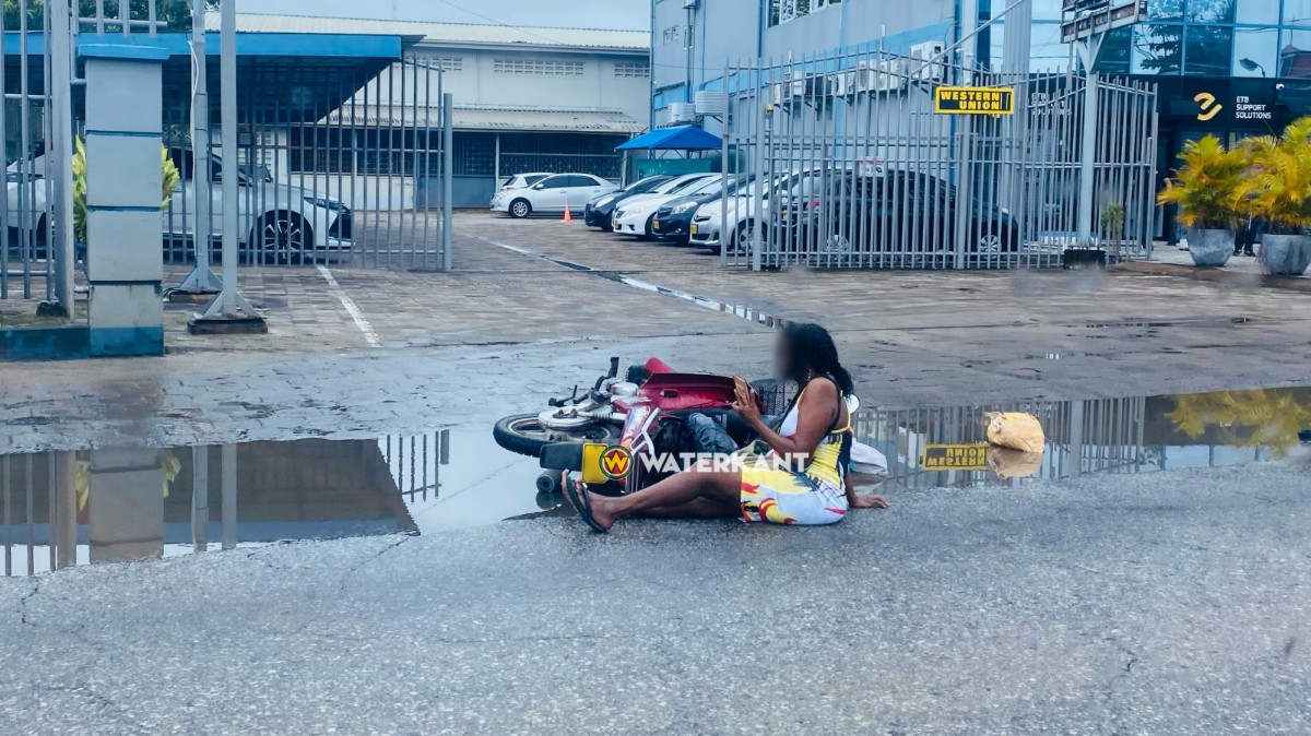 Vrouw valt met bromfiets in plas water - Waterkant